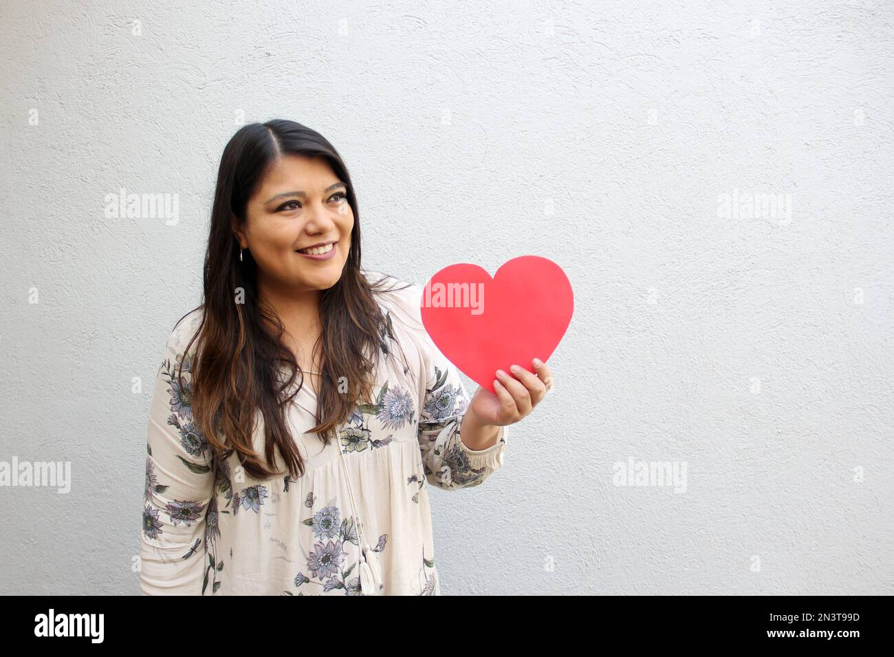 Latin adult woman shows big red heart with enthusiasm for the arrival ...