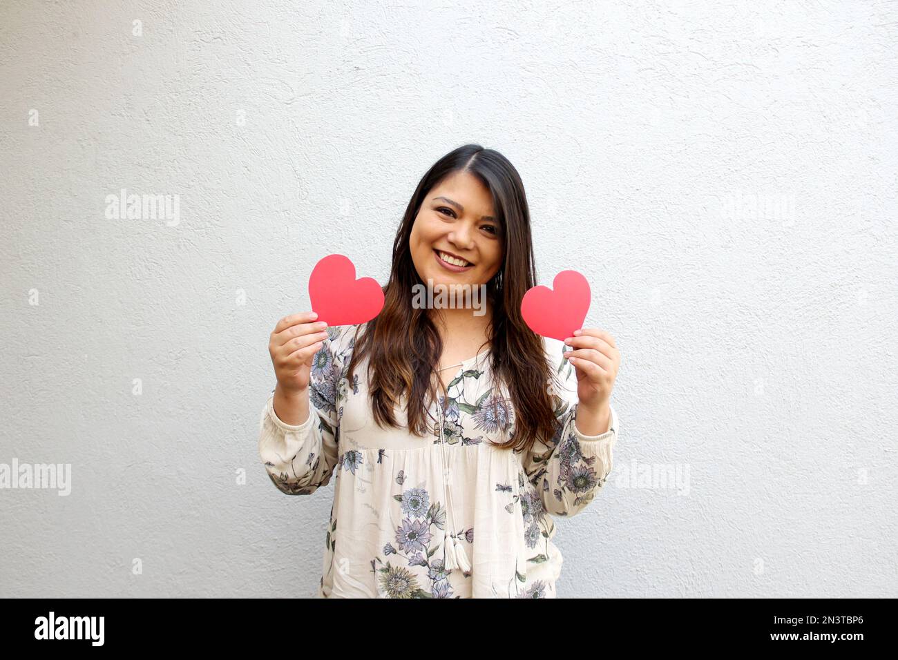 Latin adult woman shows big red heart with enthusiasm for the arrival ...