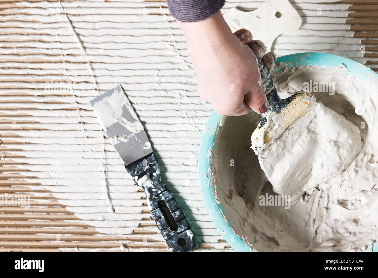 Worker hand with spatula and plaster, build work Stock Photo - Alamy