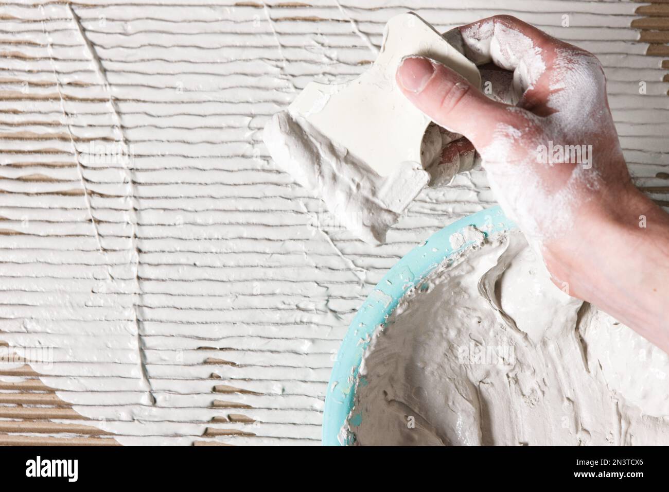 Builder hand with spatula, white plaster, flat lay Stock Photo - Alamy