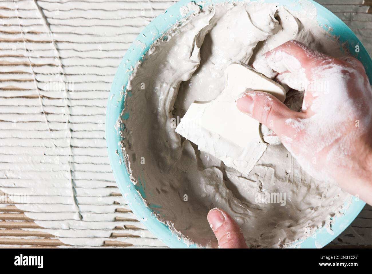 Builder hand mix plaster with spatula, repair work Stock Photo - Alamy