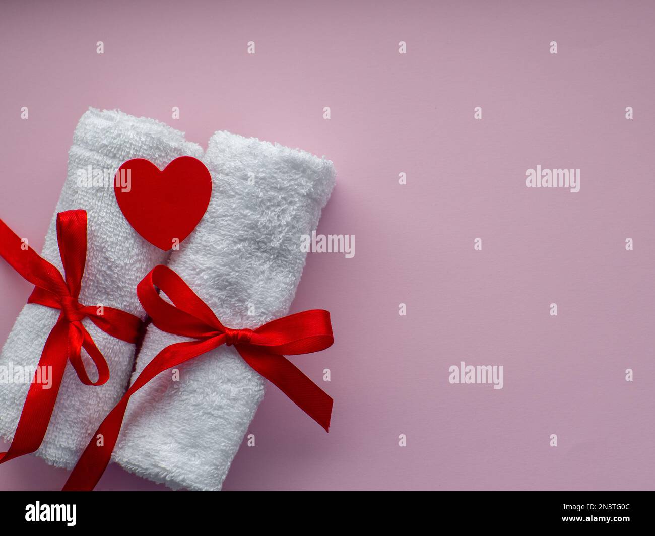 Flat lay with tiny heart-shaped paper, two white towels and space for ...