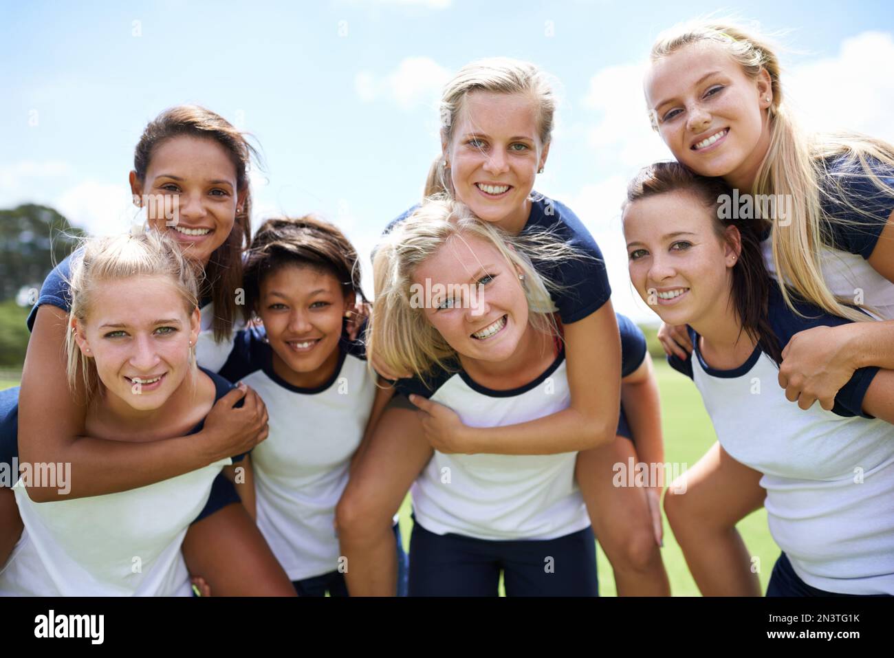 Enjoying strong team bonds. An all girls sports team standing together ...