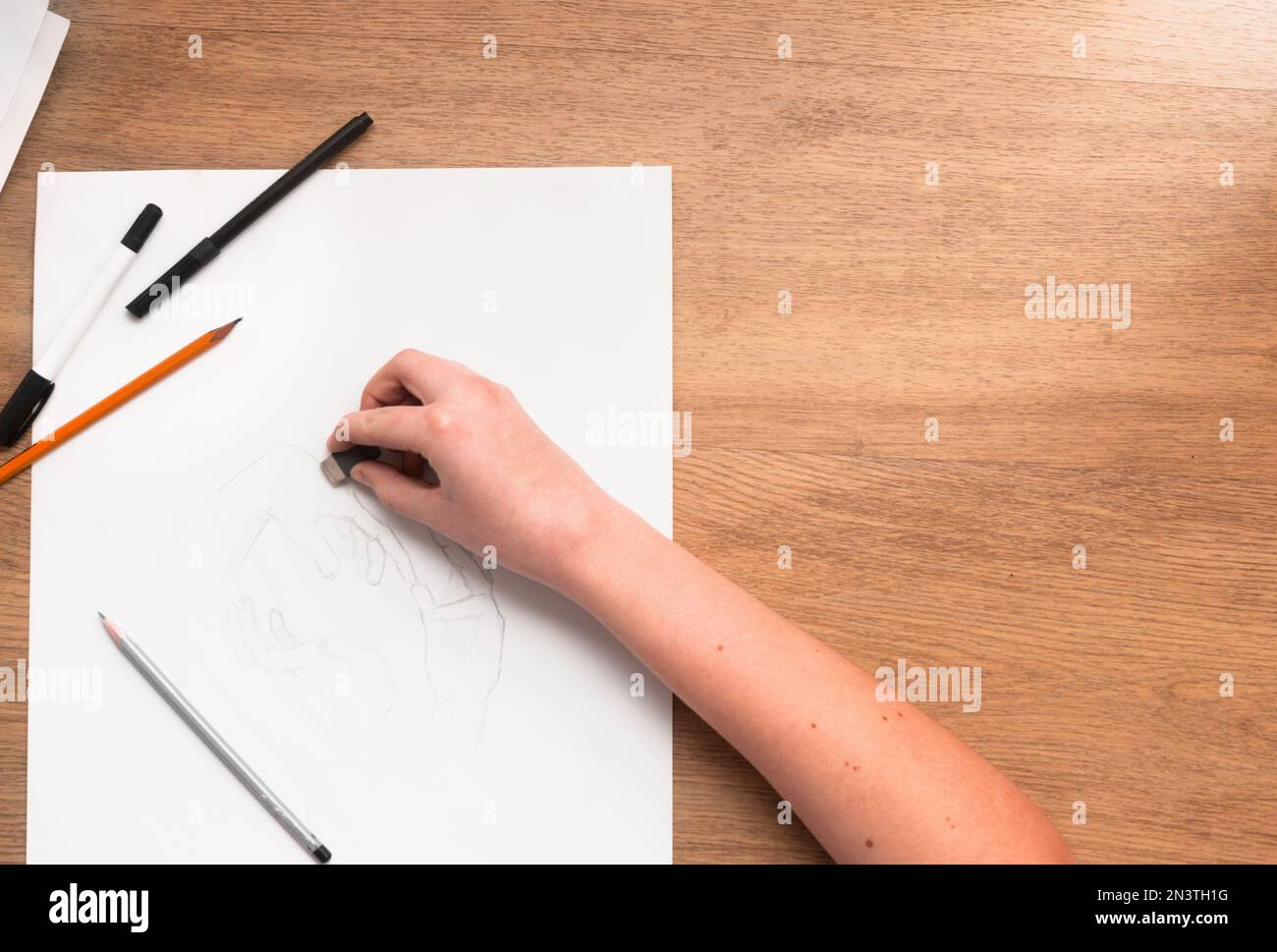 Person erasing lines on sketch Stock Photo - Alamy