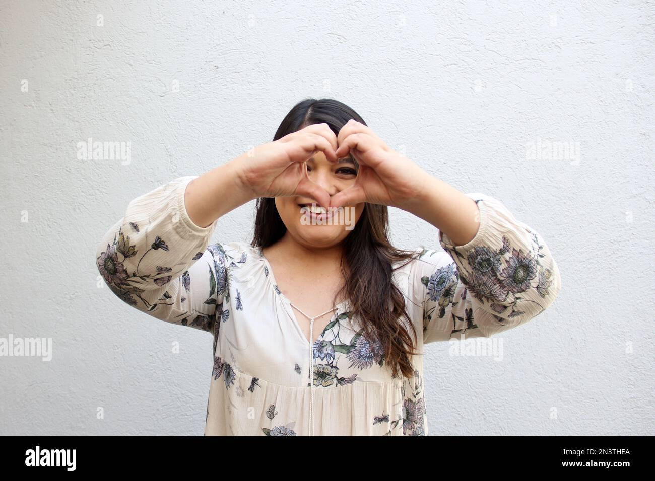 Latin adult woman shows big red heart with enthusiasm for the arrival ...