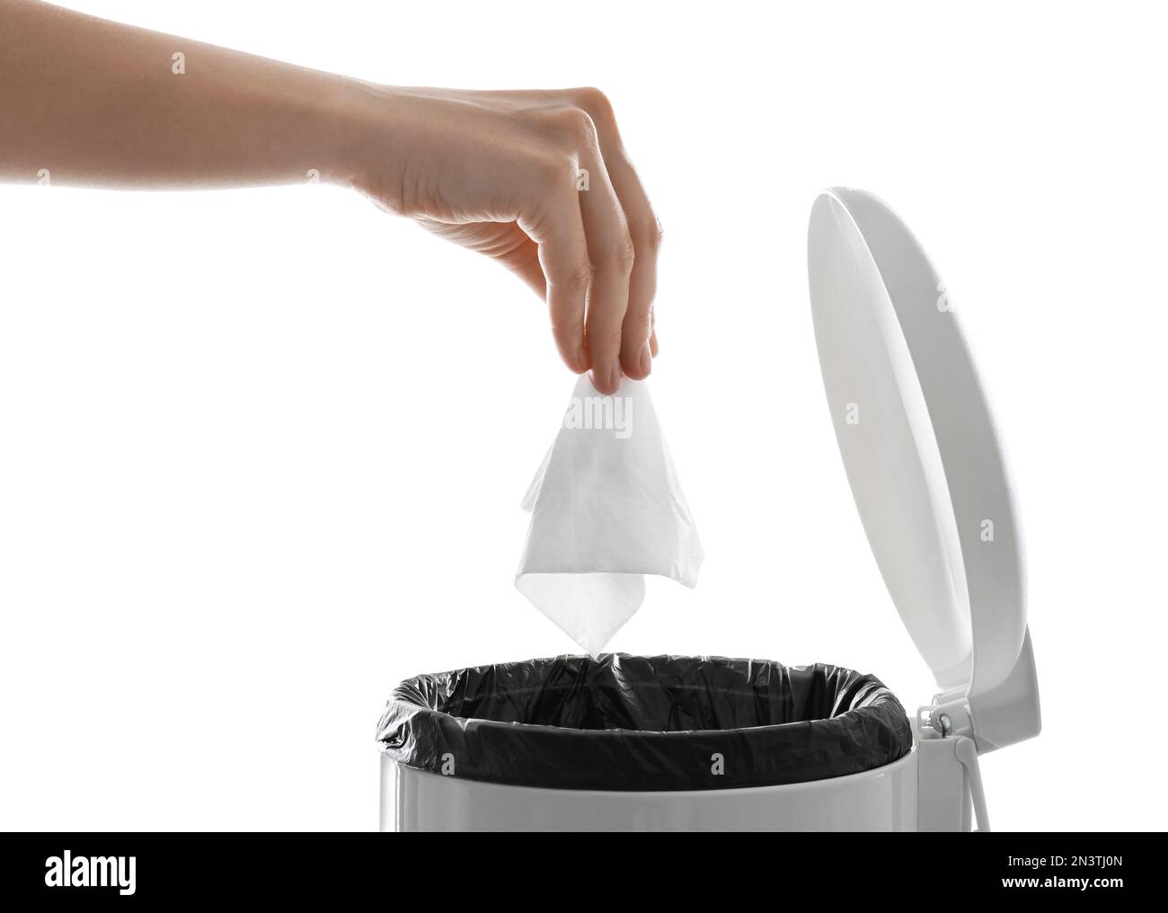 Woman putting paper tissue into trash bin on white background, closeup ...