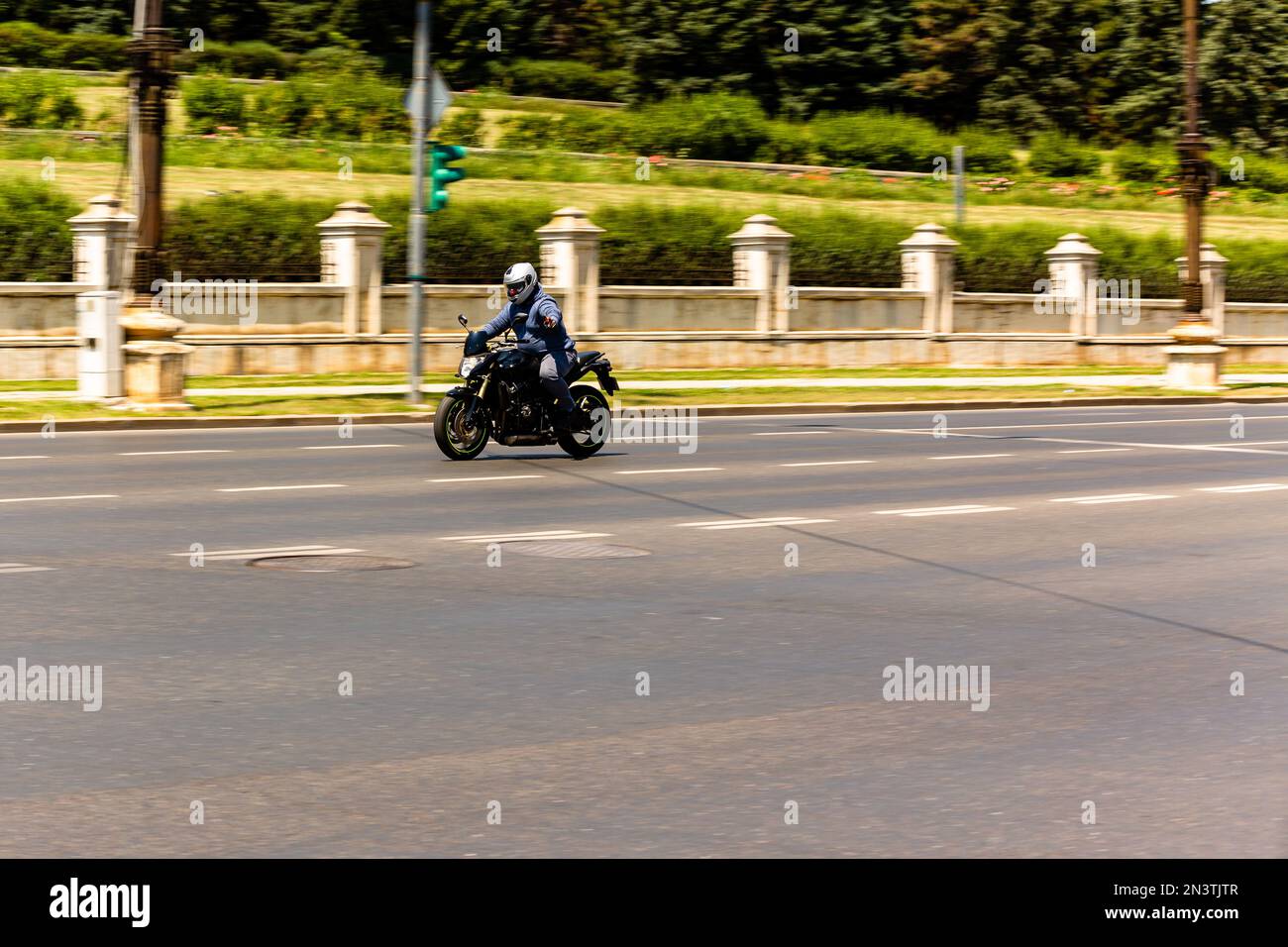 Biker on a motorcycle in traffic at rush hour in downtown area of the ...