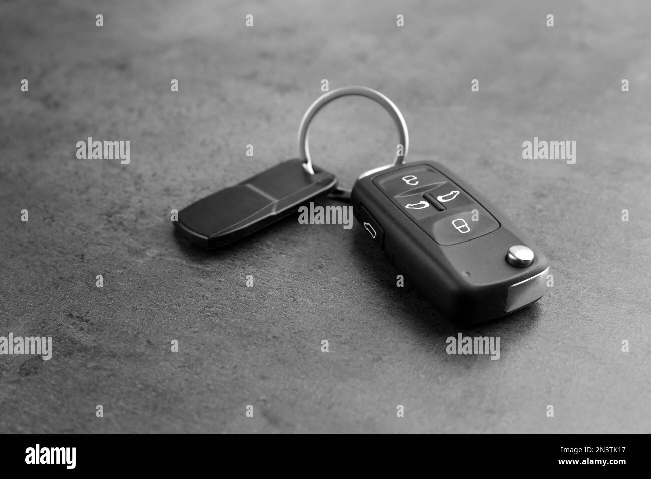 Modern car flip key with trinket on grey background Stock Photo - Alamy