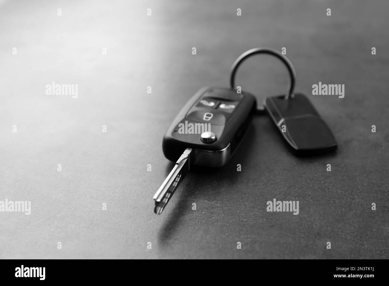 Modern car flip key with trinket on grey background Stock Photo - Alamy
