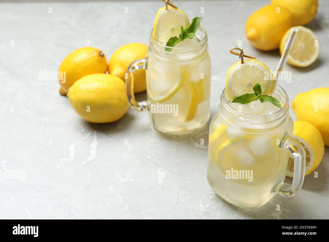 Natural lemonade with mint and fresh fruits on light grey marble table ...