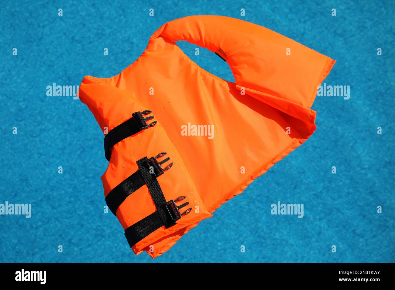 Bright orange life jacket floating in swimming pool, top view Stock ...