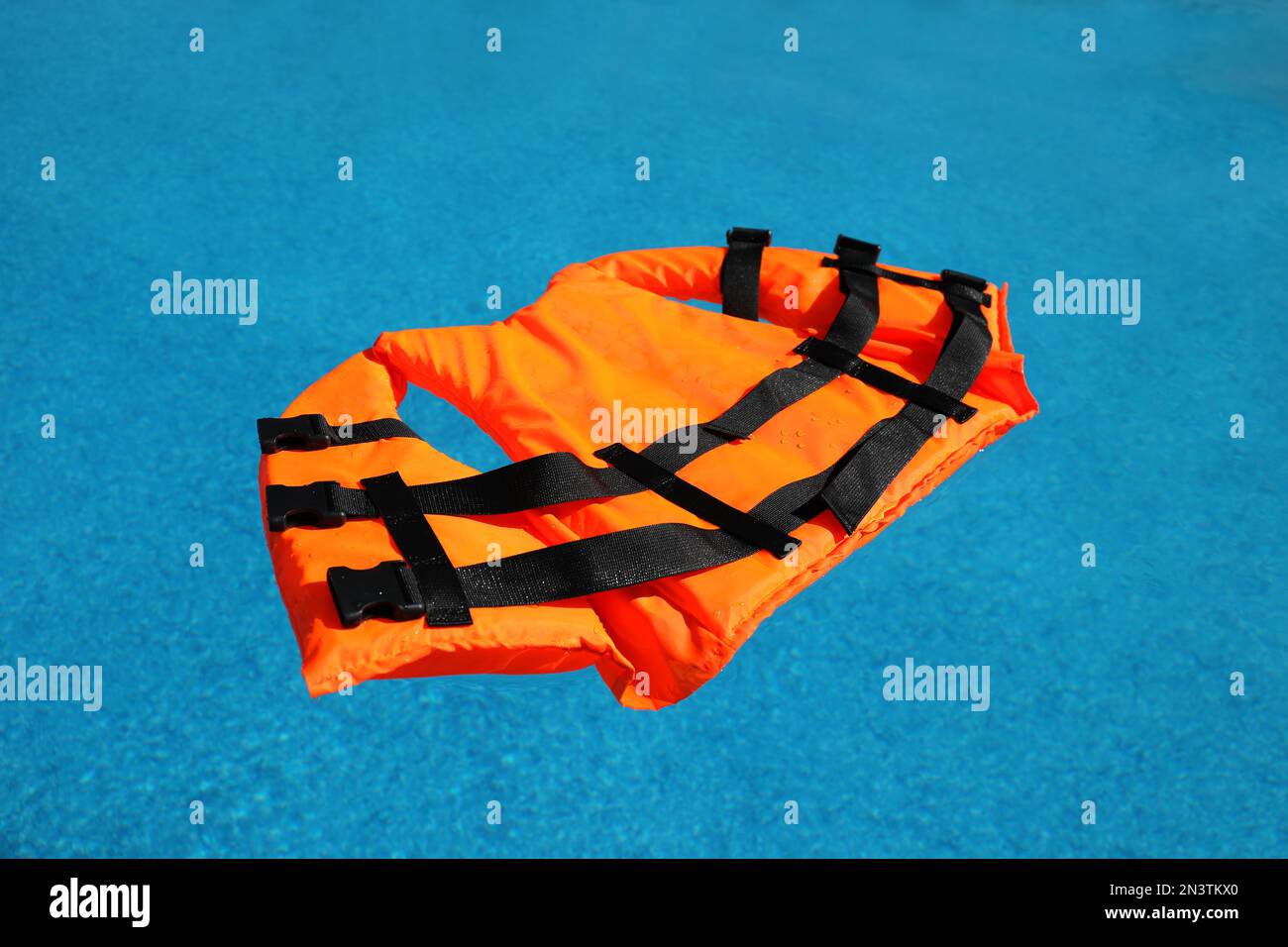 Bright orange life jacket floating in swimming pool Stock Photo - Alamy