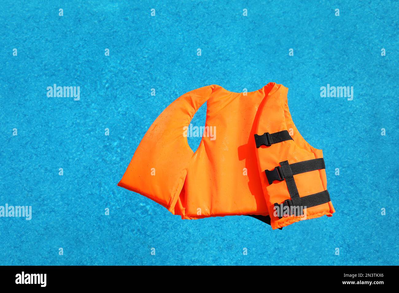 Bright orange life jacket floating in swimming pool, top view Stock ...