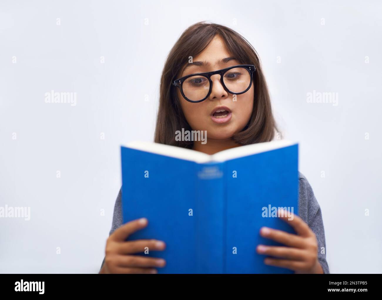 Doing her prepared reading. Young girl reading aloud from her book ...