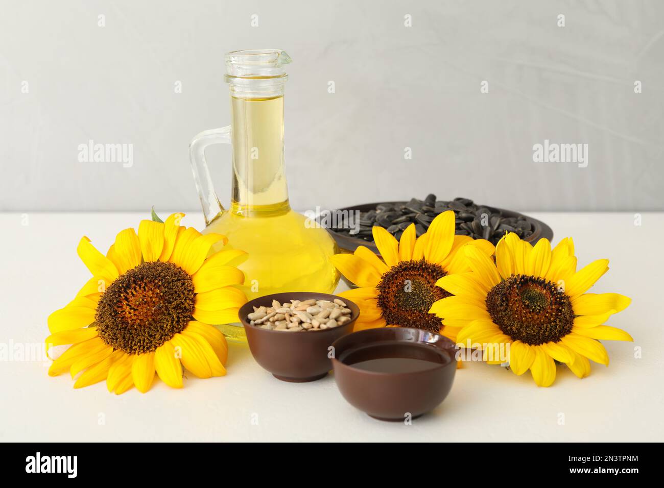Composition with sunflower oil on white table Stock Photo - Alamy