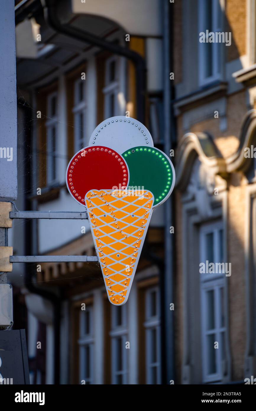 A vertical shot of an ice cream cone sign on the wall of an ice cream ...