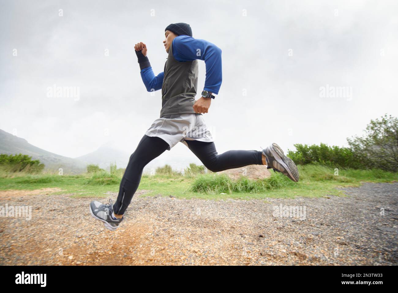 Training in the great outdoors. A young man running in rugged outdoor ...