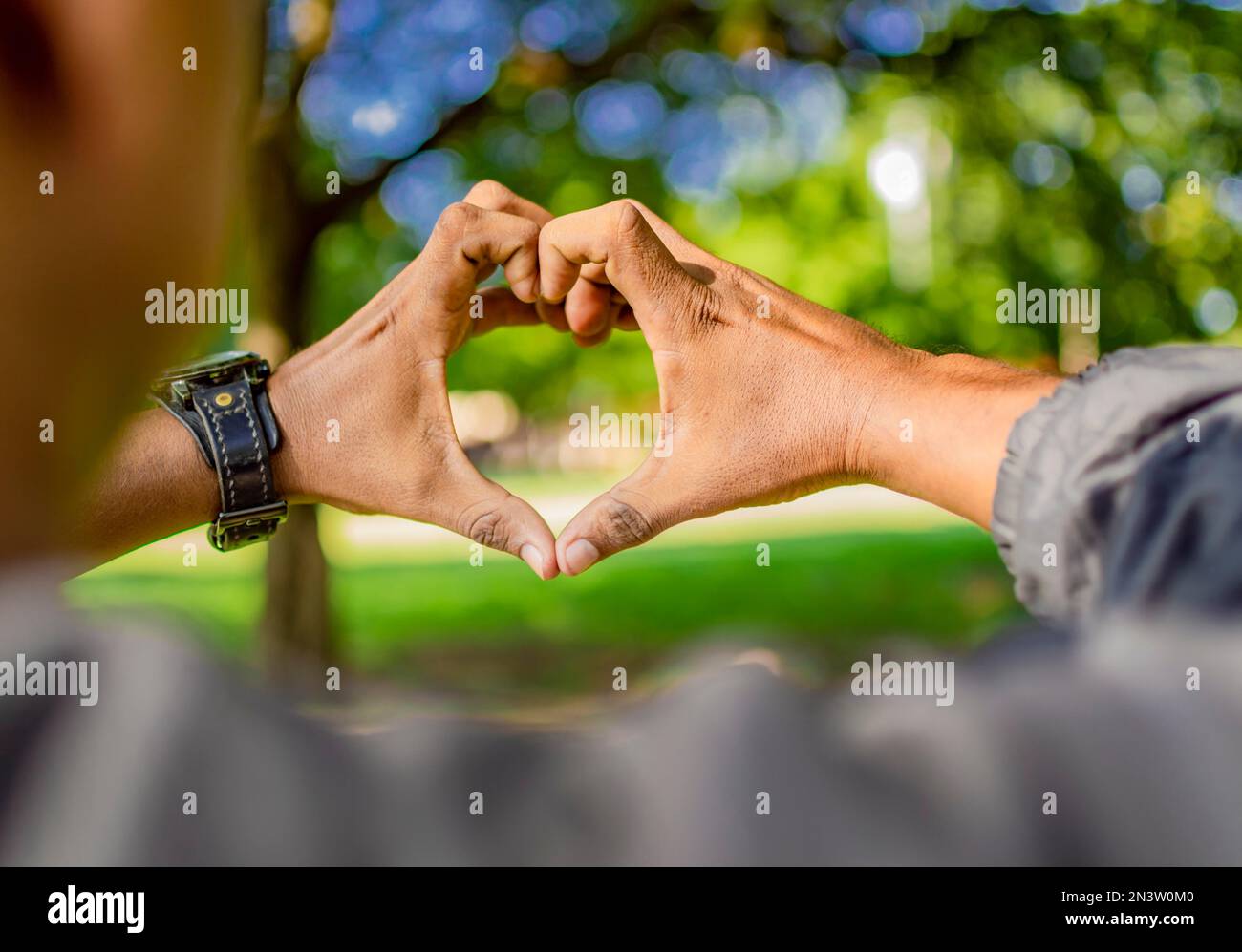 Close up of two hands together in a heart shape, hands together in a ...