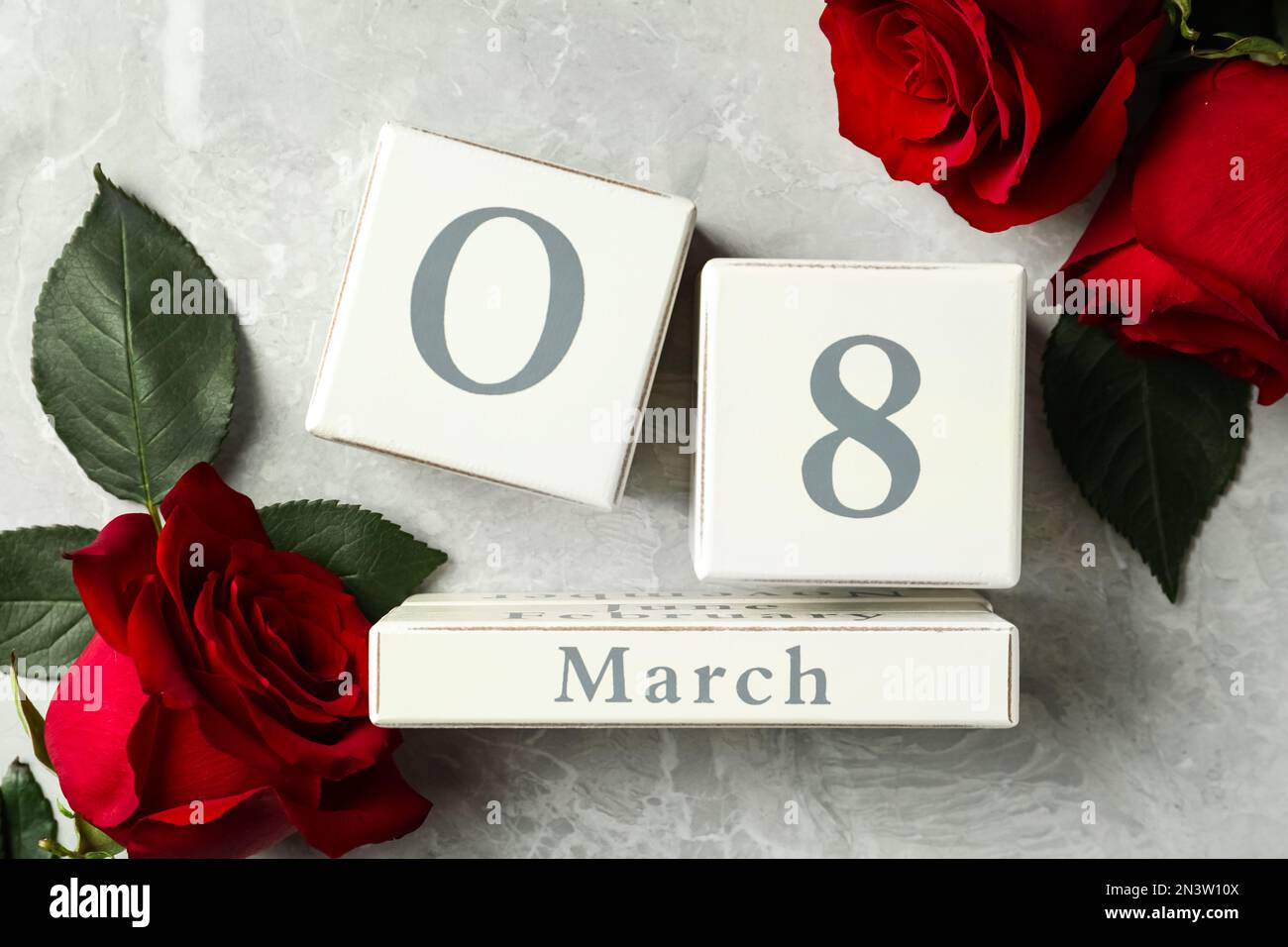 Block calendar with date 8th of March and roses on light grey marble ...
