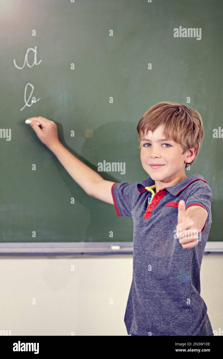Good job. a little boy showing thumbs up while writing on the ...