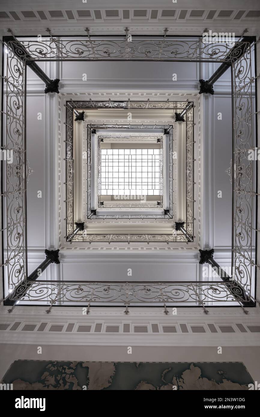 View upwards, white corridor, historic office building with railings ...