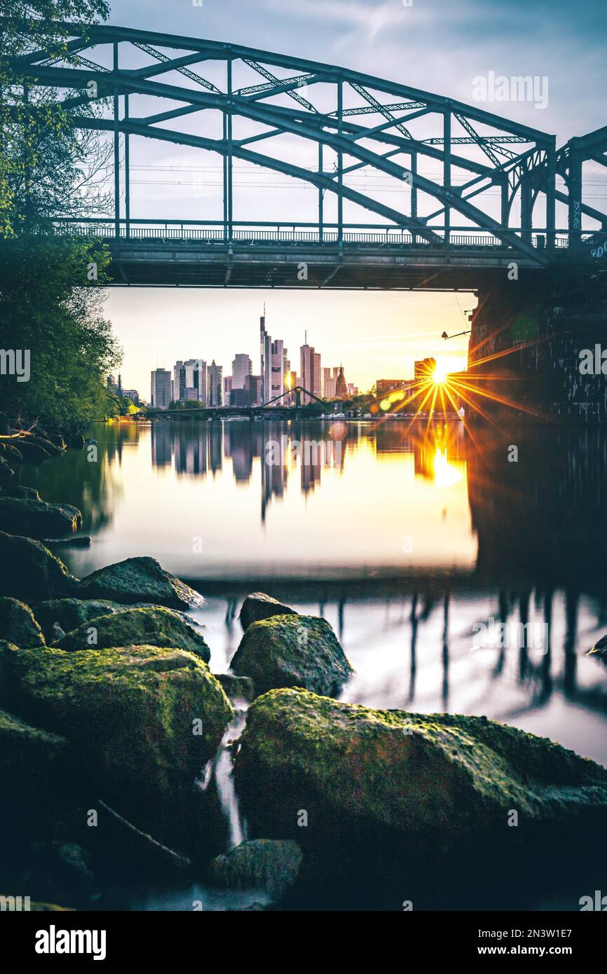 View under a railway bridge over the river Main, up to the skyline with ...