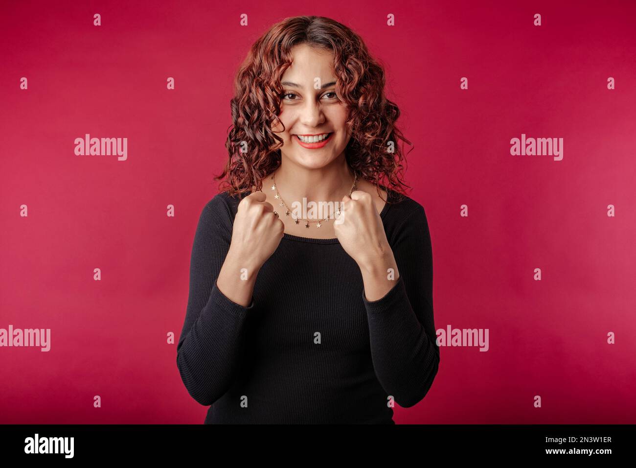 Cute millennial woman wearing black ribbed dress standing isolated over ...