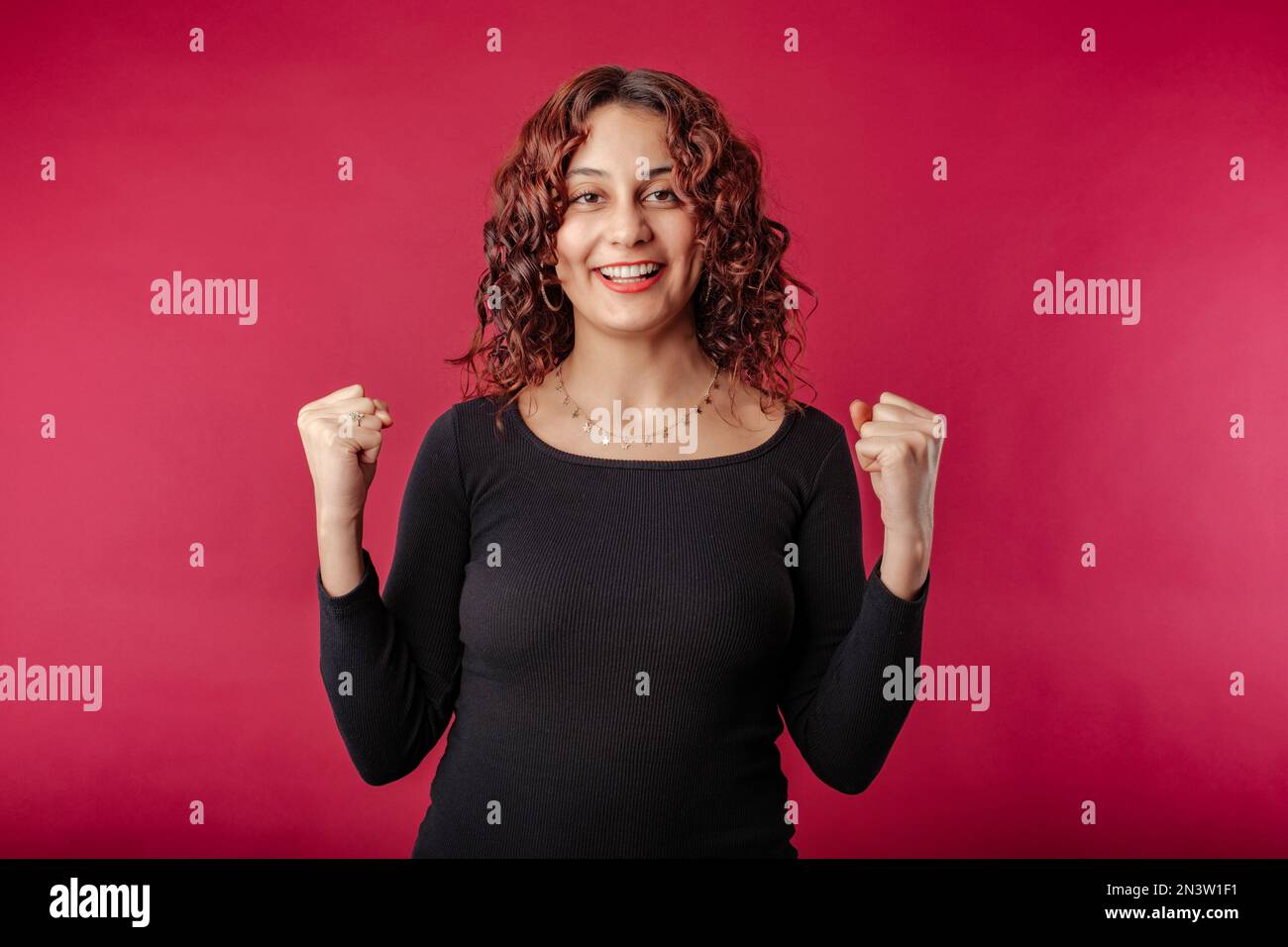 Cute caucasian woman wearing black ribbed dress isolated over red ...