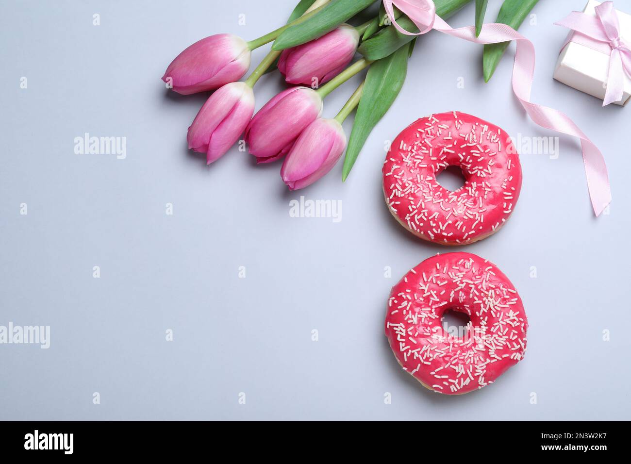 8 March greeting card design with tulips, donuts, gift box and space ...