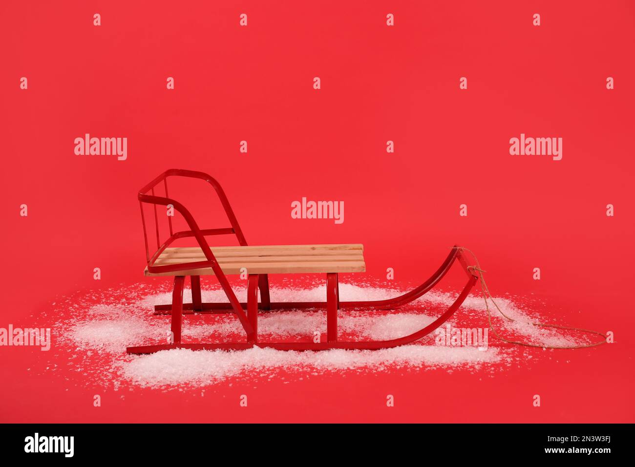 Empty sleigh and snow on red background Stock Photo - Alamy