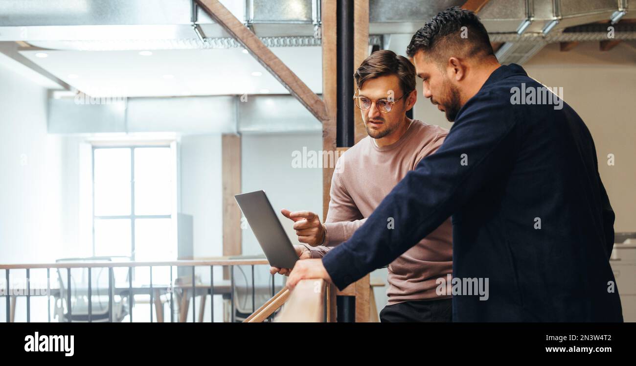 business man discussing a tech project with his colleague in an office ...