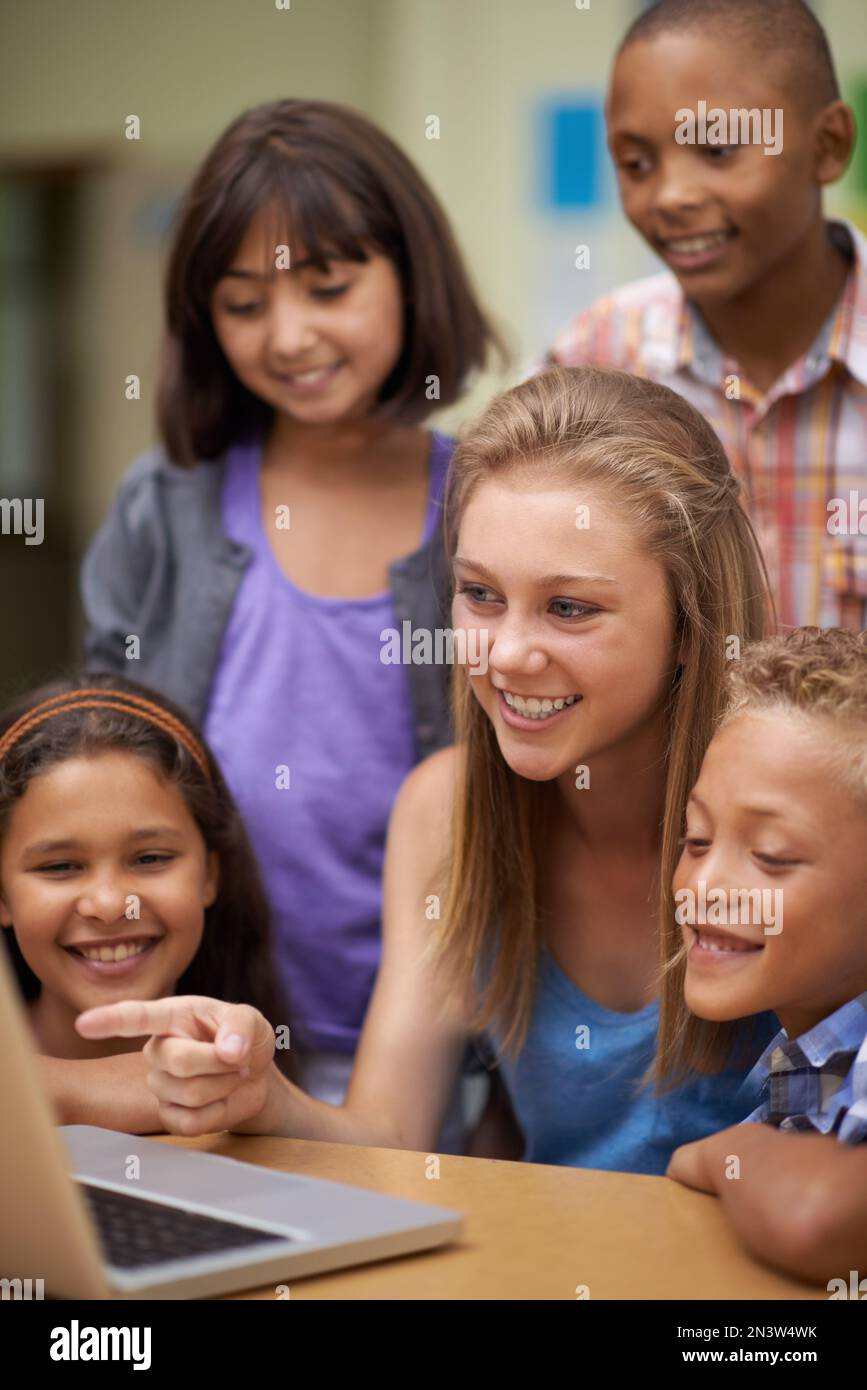 Showing her friends something on her pc during computer class. A group ...