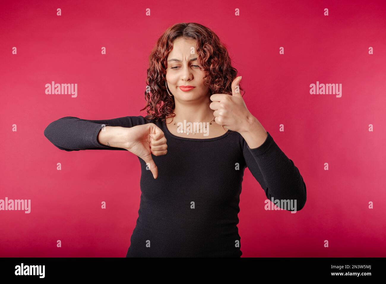 Portrait of young redhead woman wearing black dress standing isolated ...