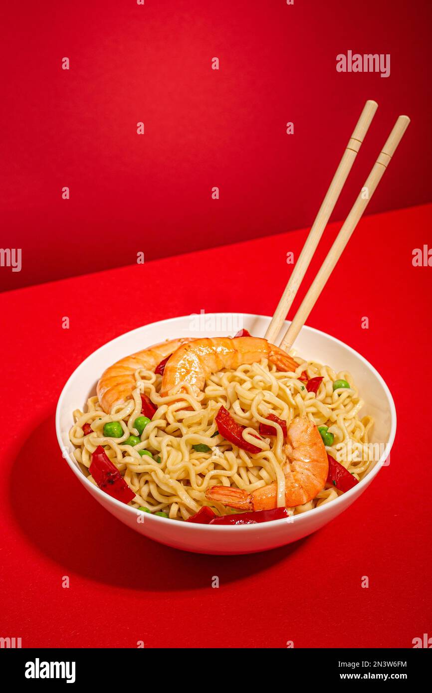 Asian Chinese noodles with shrimps and vegetables in white bowl with ...