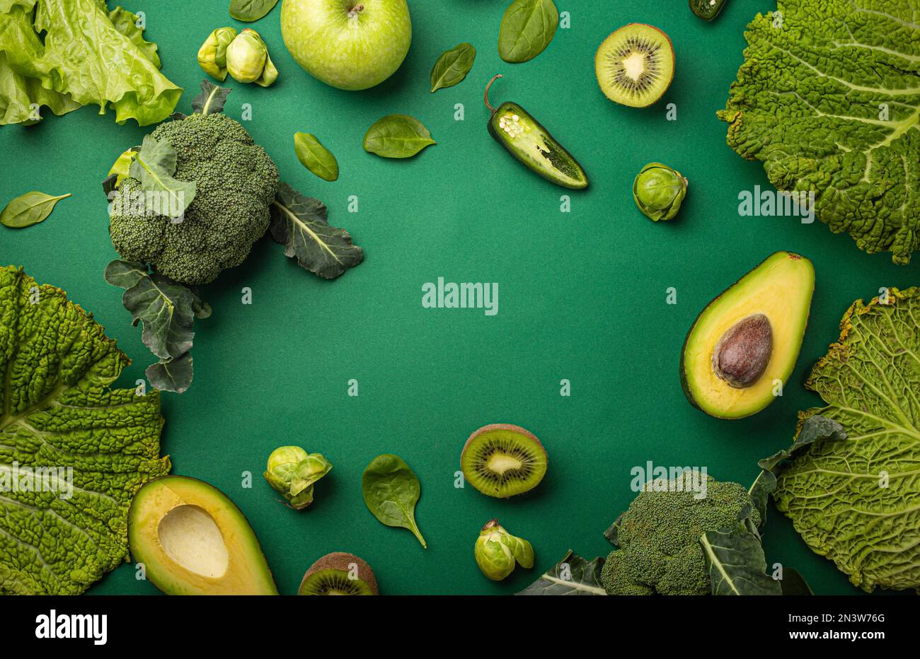 Creative layout food concept made of green fruit and vegetables on green background flat lay ...