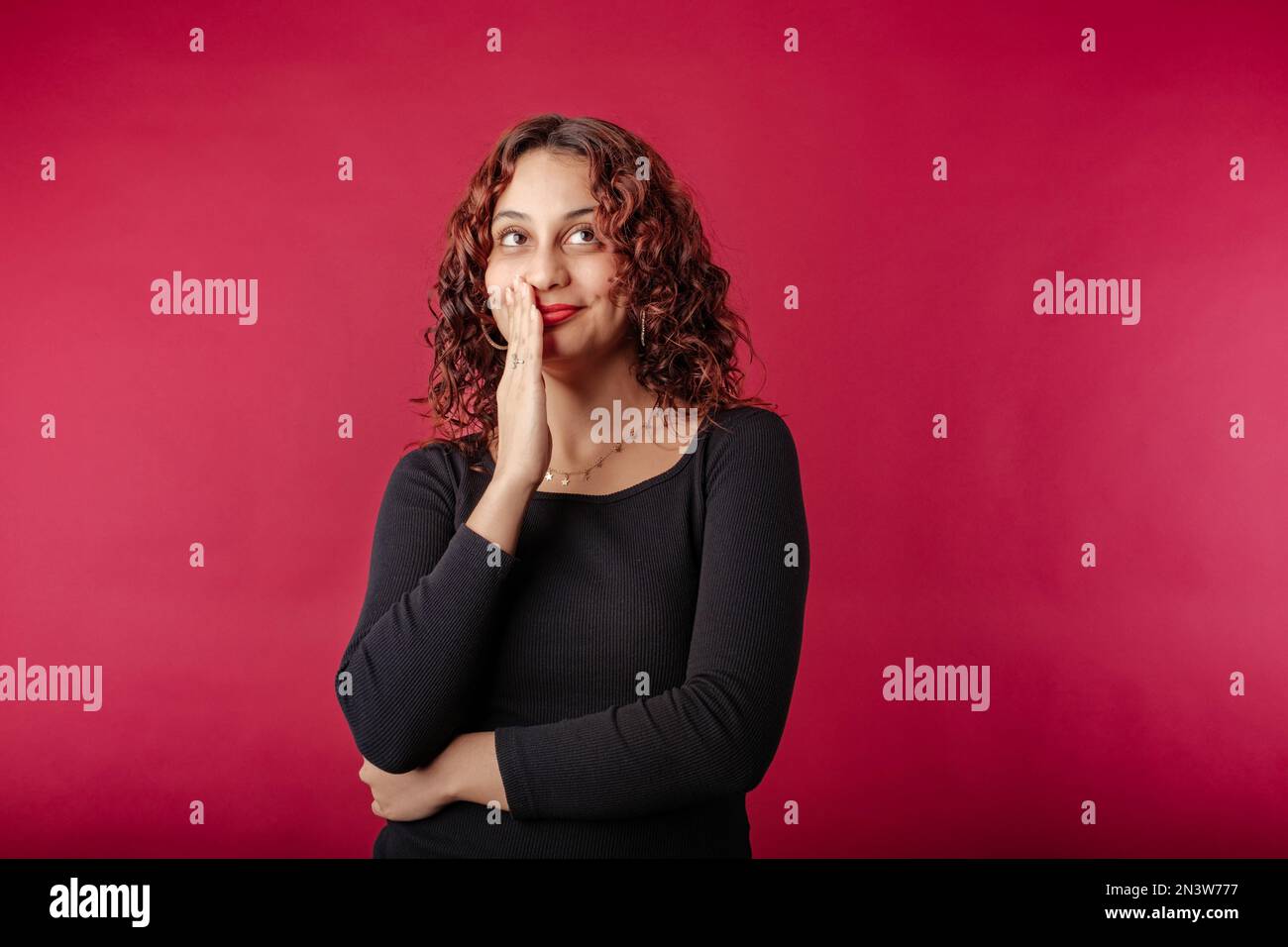 Portrait of young redhead woman standing isolated over red background ...