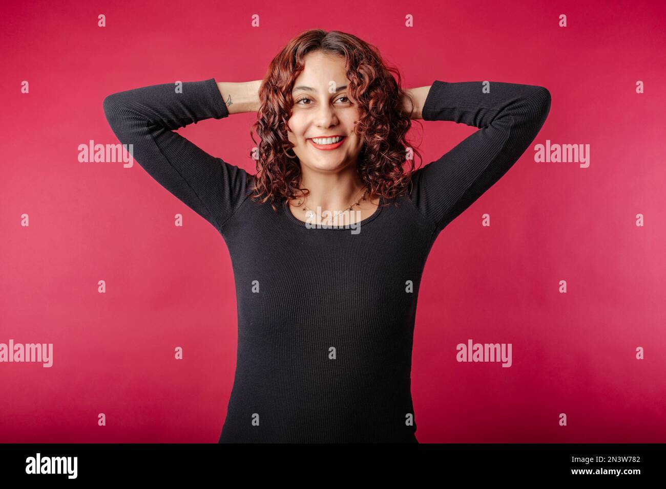 Happy Woman Wearing Black Dress Standing Isolated Over Red Background