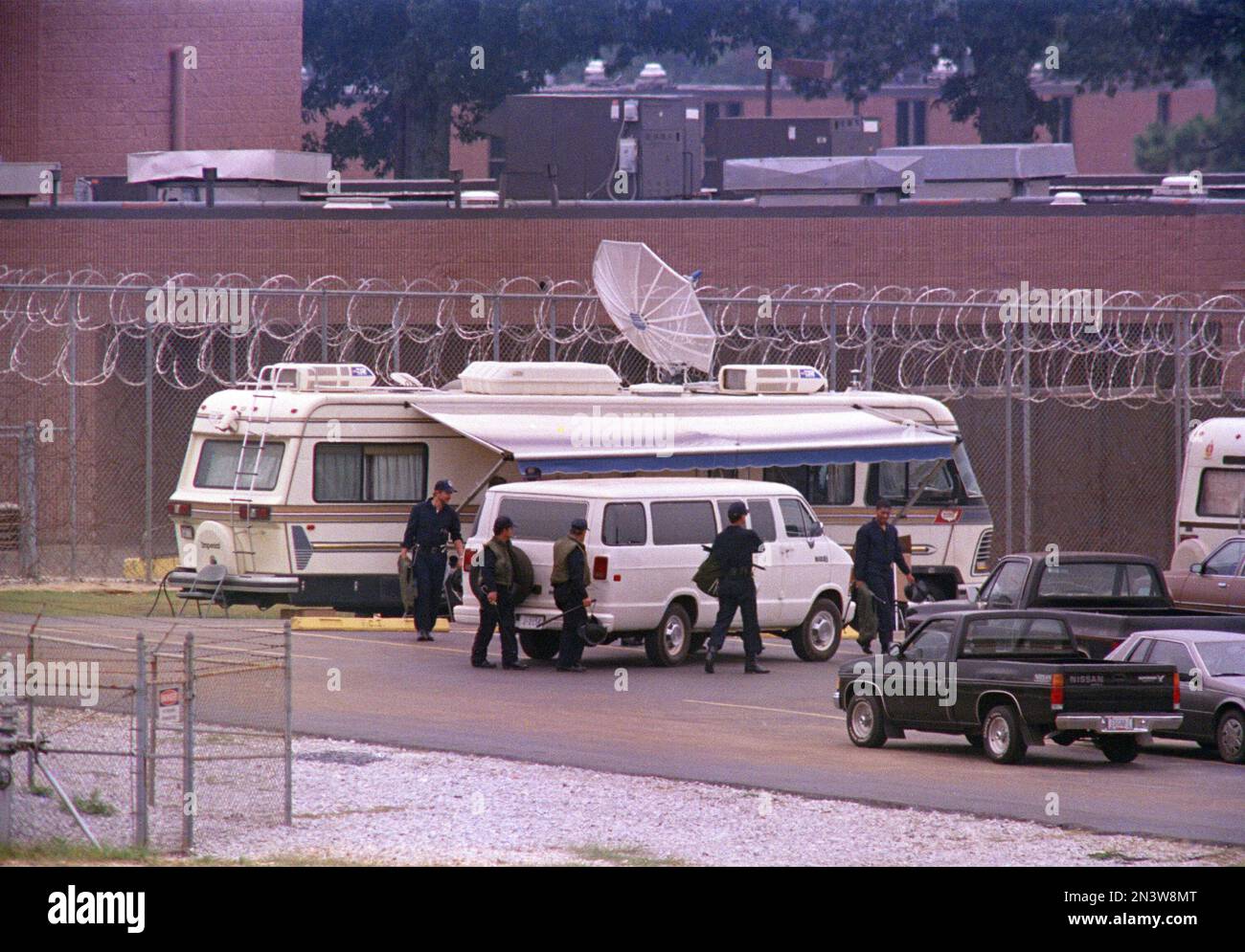 Members of an FBI SWAT team carry their gear towards a waiting van at ...