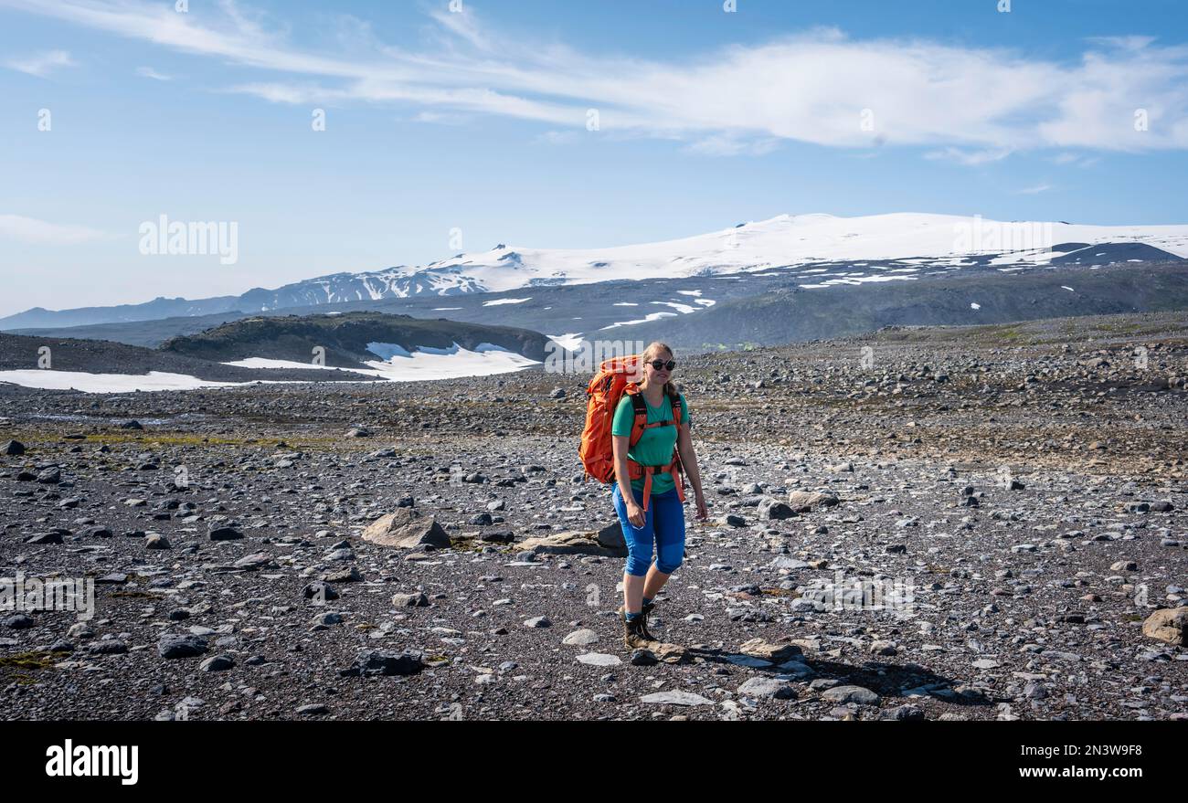 Hiker on the Fimmvoerouhals hiking trail, barren volcanic landscape ...
