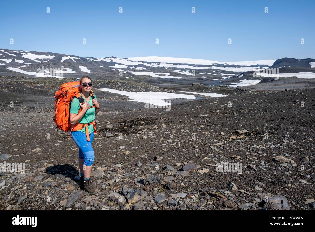 Hiker on the Fimmvoerouhals hiking trail, barren volcanic landscape ...