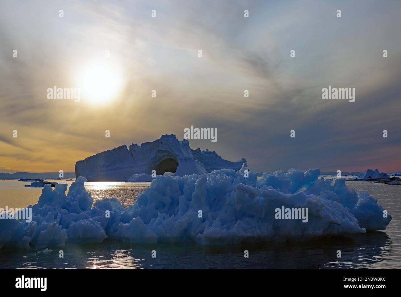Huge icebergs and drift ice in the glow of the midnight sun, Disko Bay ...