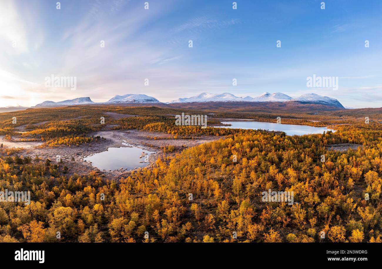 Autumnal fell landscape with small lakes in front of snowy mountain ...