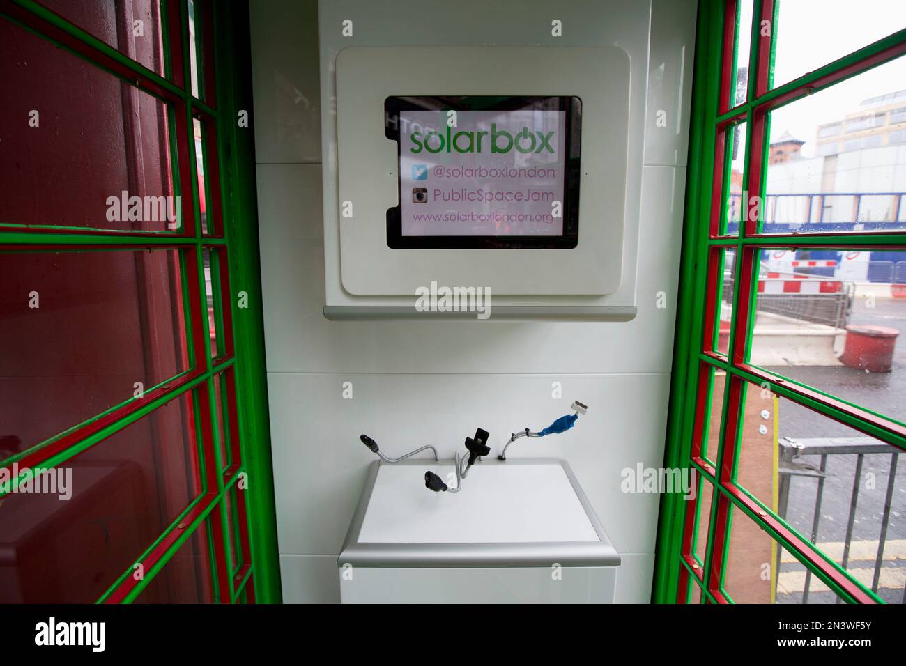 Mobile phone charging points lie ready for people to use inside a green ...