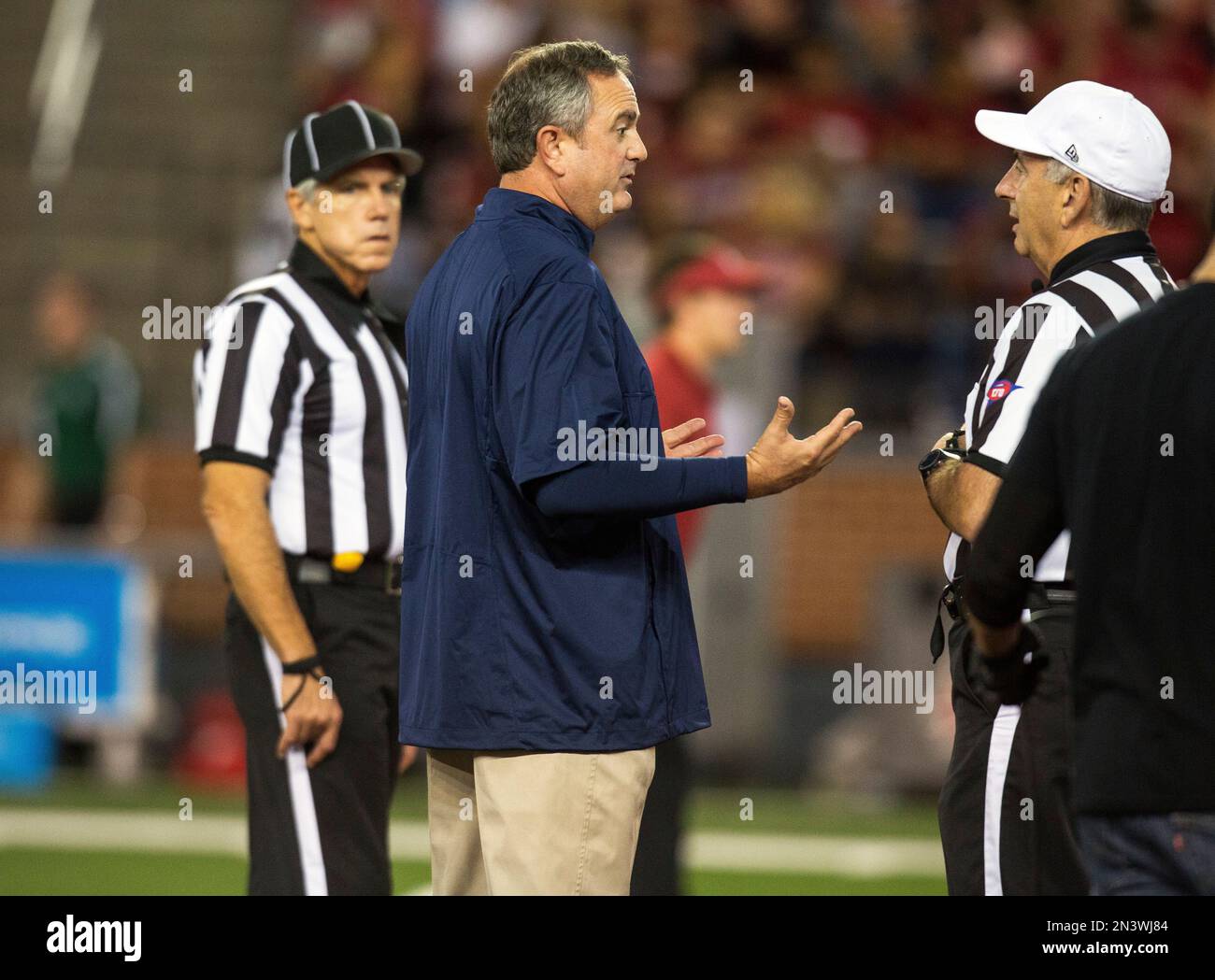 California head coach Sonny Dykes, center, talks with referee Michael ...