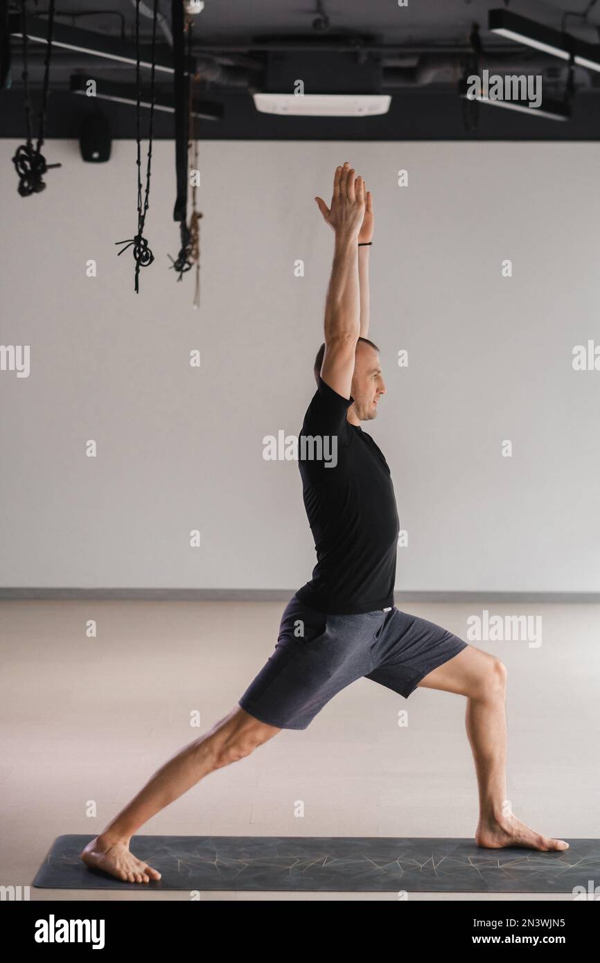 An athletically built man does yoga in the gym on a mat Stock Photo - Alamy
