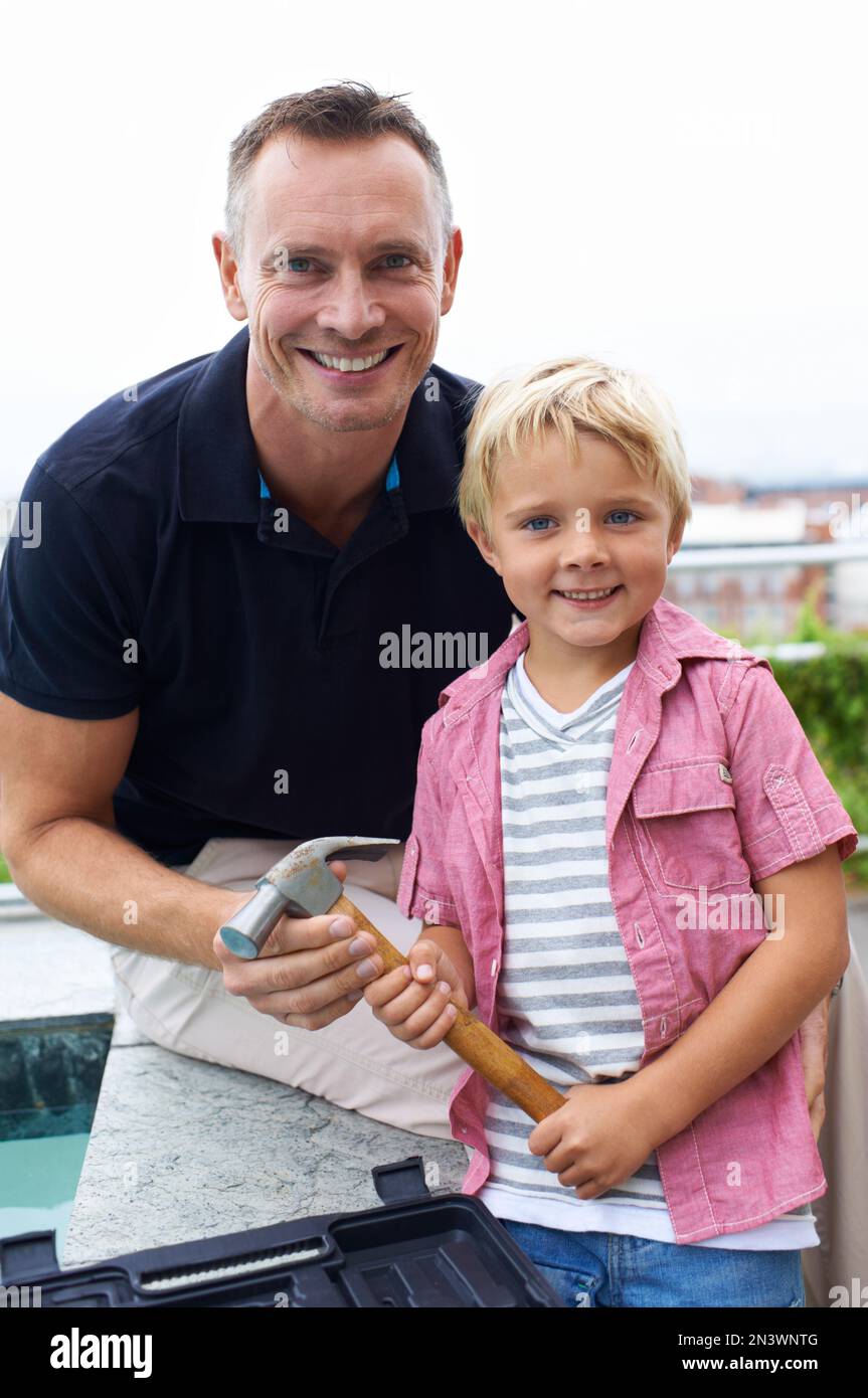 Learning from dad. Portrait of a handsome father teaching his son how ...