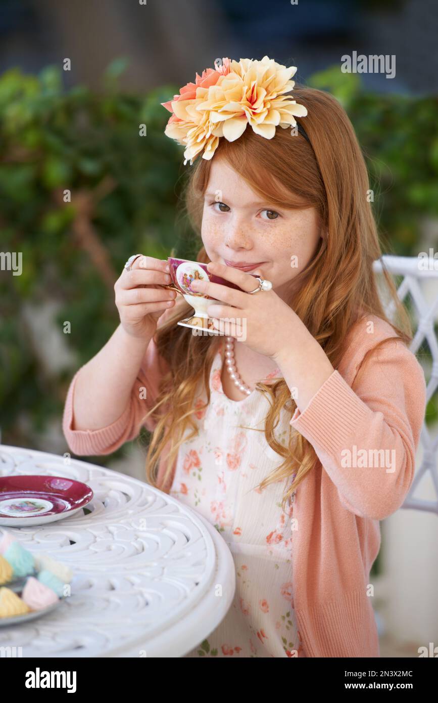 Hostess of the tea party. A cute little girl having a tea party outside ...