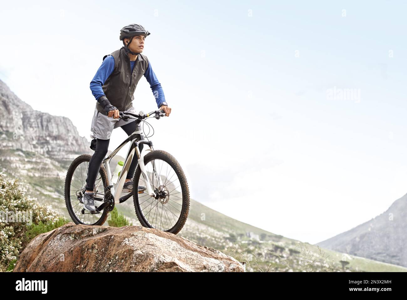 What a magnificent trail. A young man riding a mountain bike on rough ...