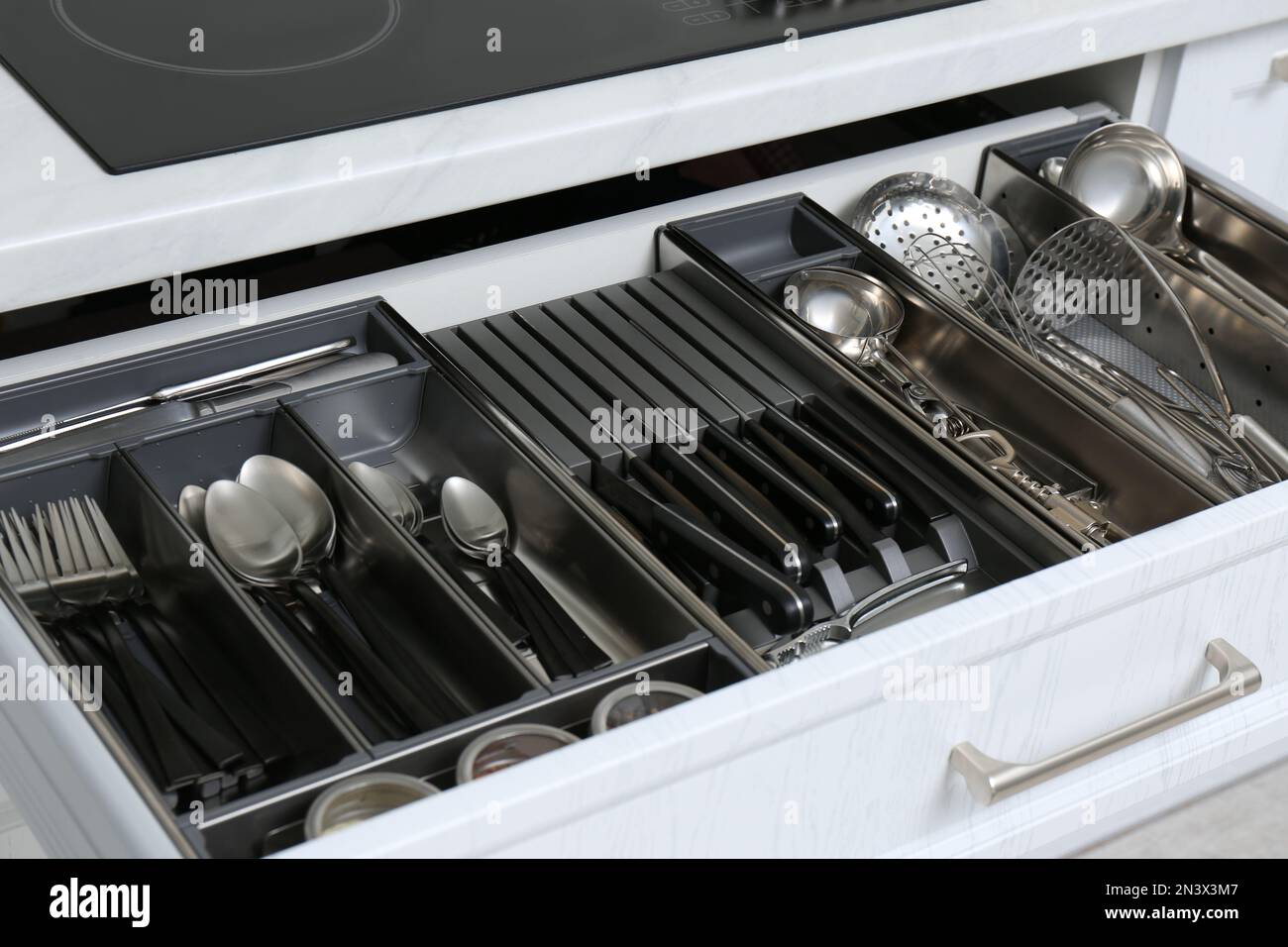 Open drawer with stainless steel utensil set, closeup. Order in kitchen ...