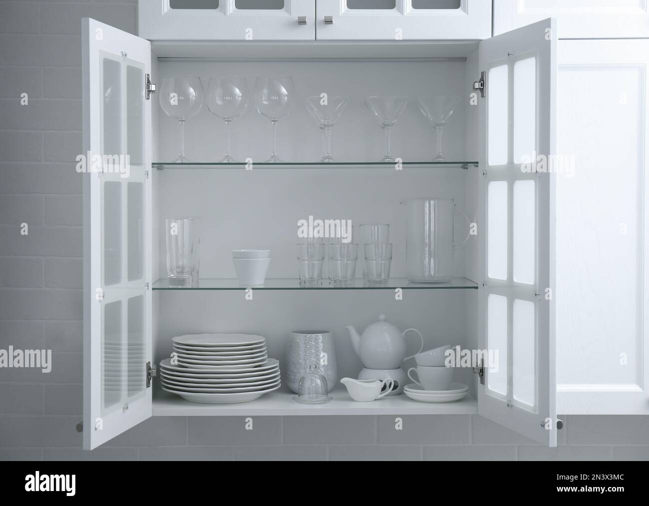 Cabinet with crockery and glassware. Order in kitchen Stock Photo - Alamy